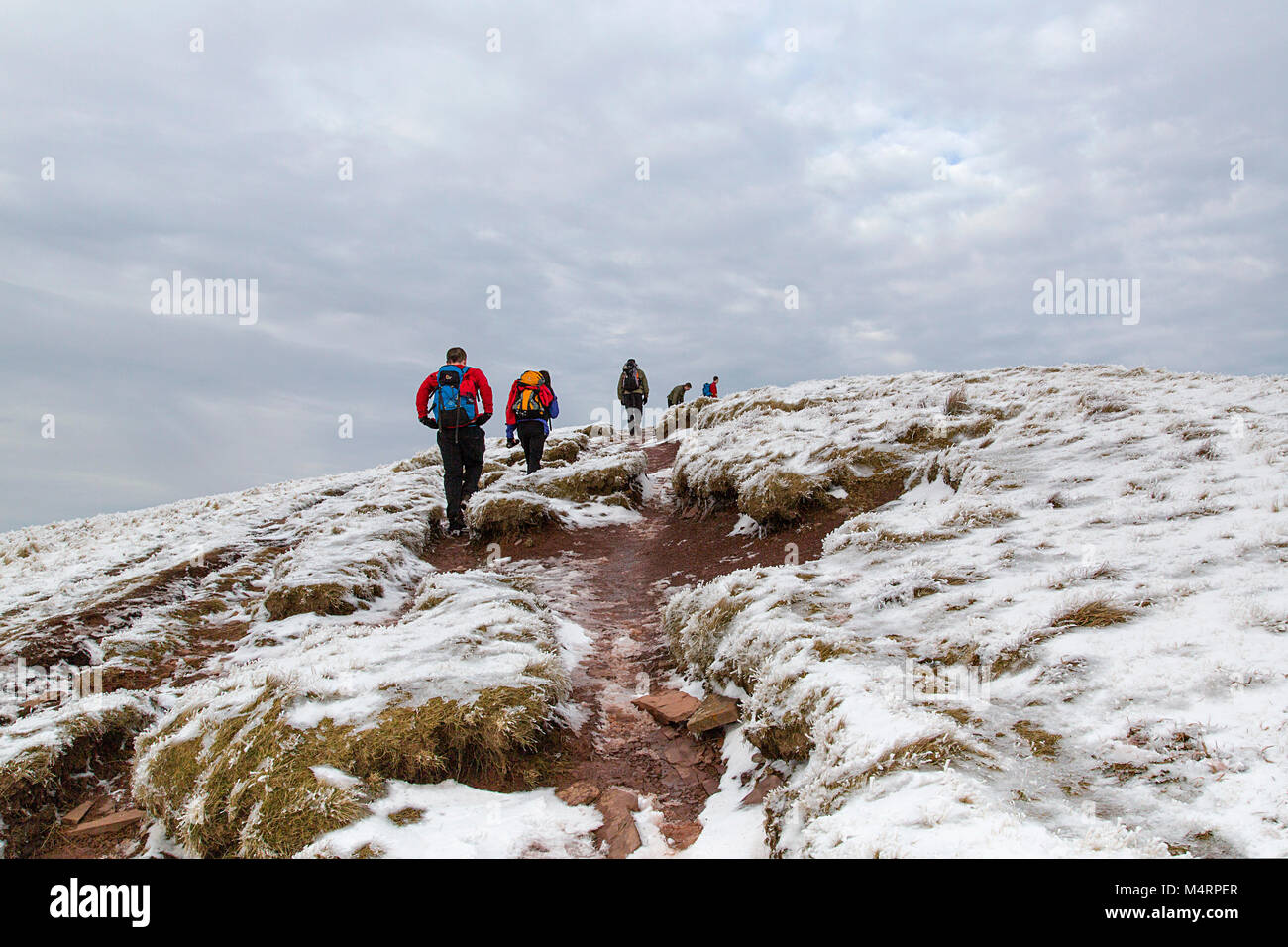 Brecon, Wales, UK: February 07, 2018: Five people climb to the summit ...