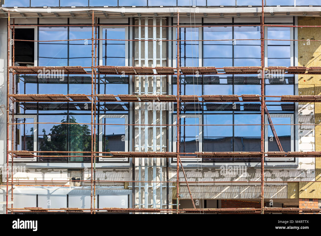 modern office building under construction. scaffolding at building site ...