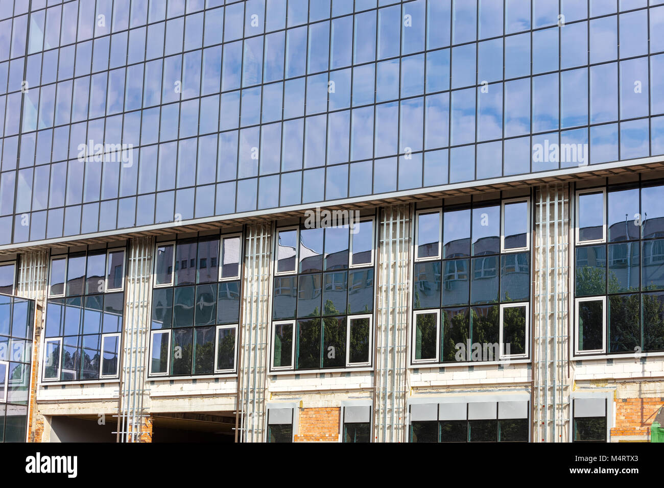 high-rise glass office building under construction with cloudy sky ...