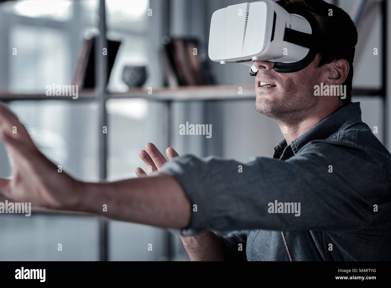 Millennial guy wearing virtual reality goggles Stock Photo - Alamy