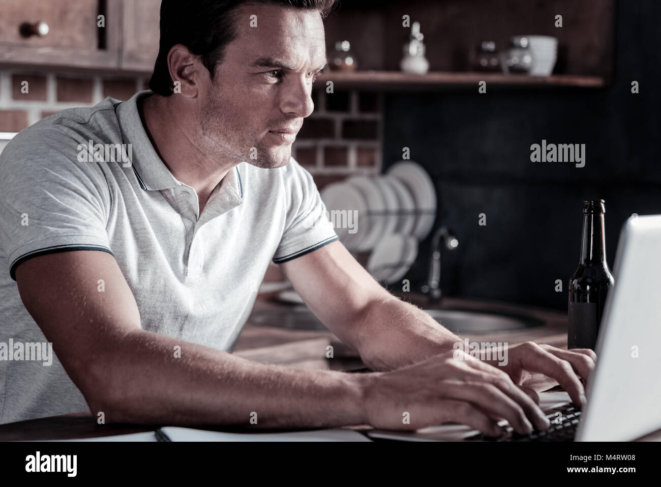Motivated millennial guy working on laptop Stock Photo - Alamy