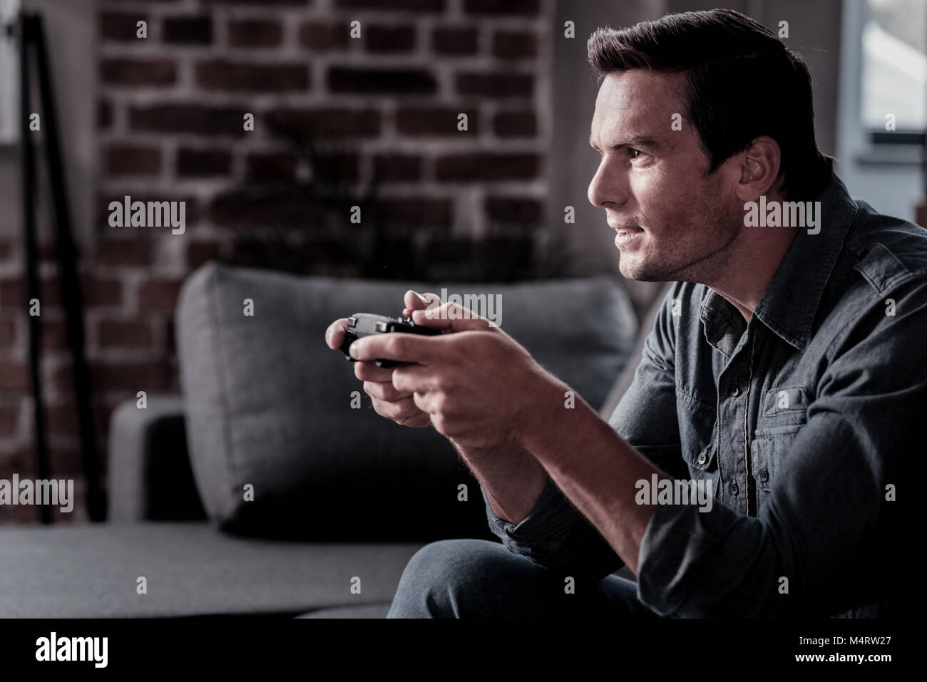 Handsome mature guy playing video games at home Stock Photo - Alamy
