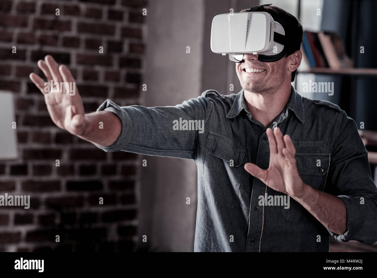 Radiant guy playing video games while wearing vr headset Stock Photo ...