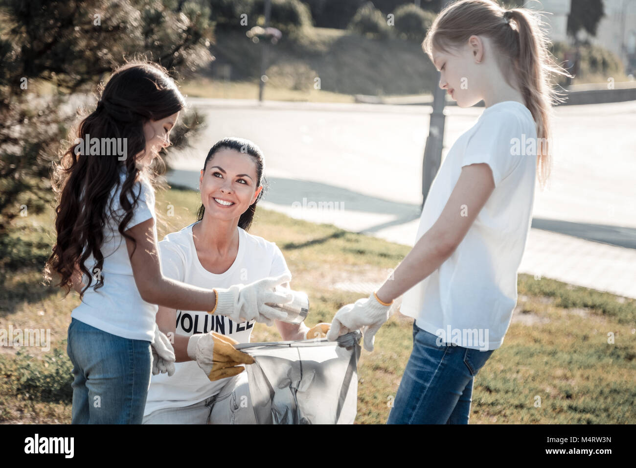 Delighted positive woman helping the children Stock Photo - Alamy