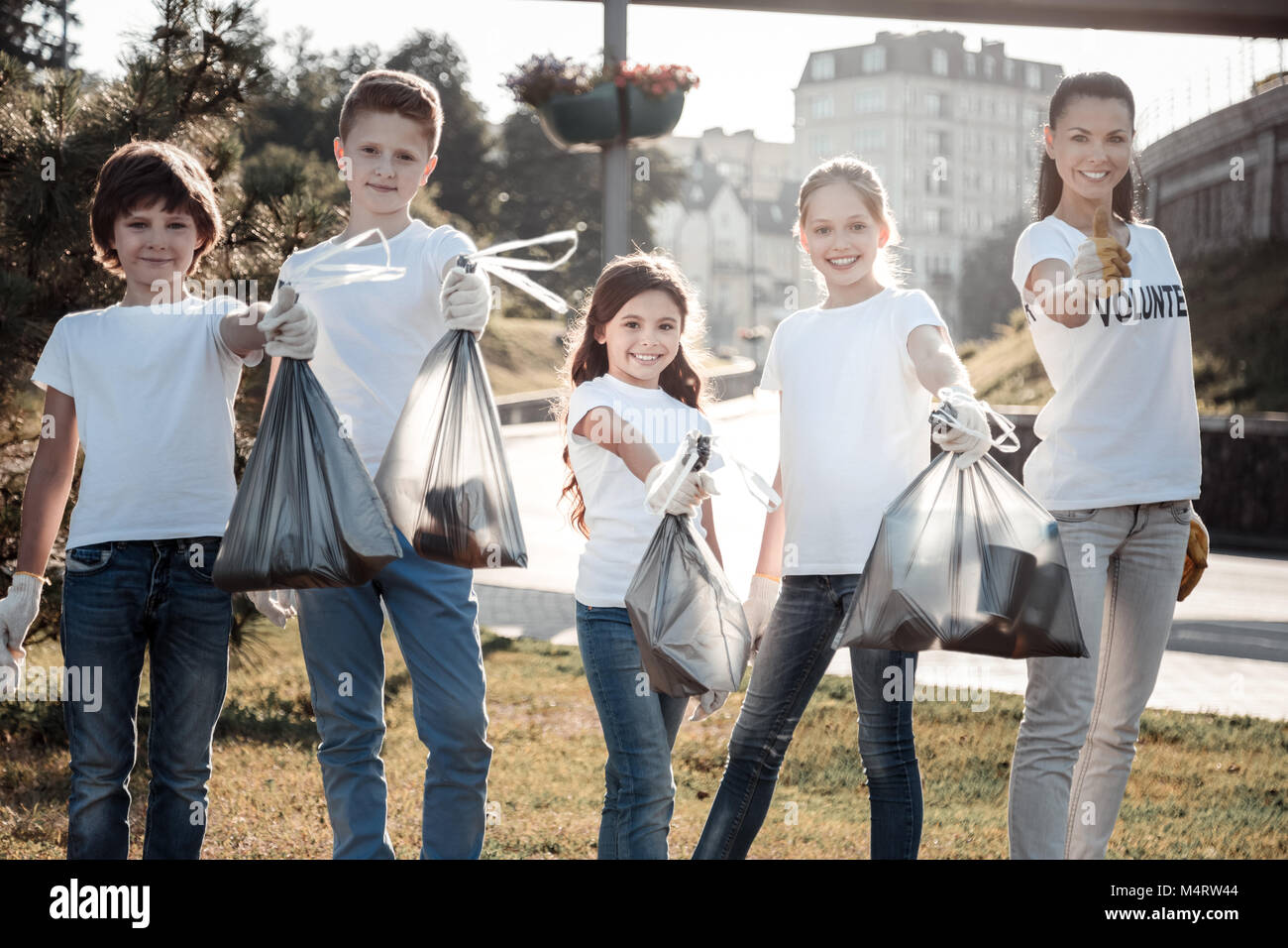 Nice cheerful children holding litter bags Stock Photo - Alamy