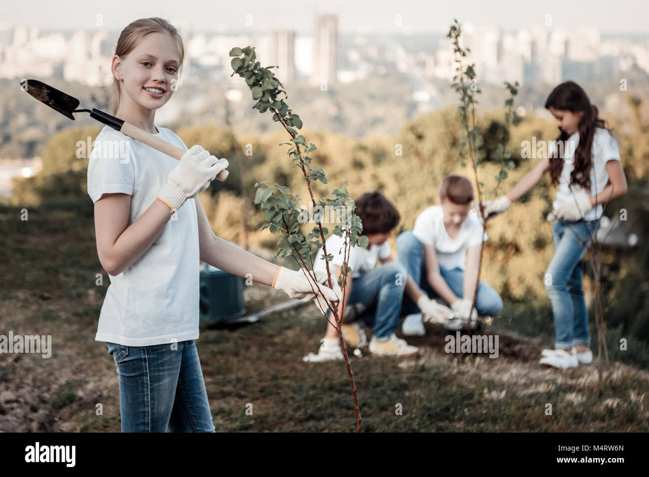Cute smiley girl holding a spade Stock Photo - Alamy