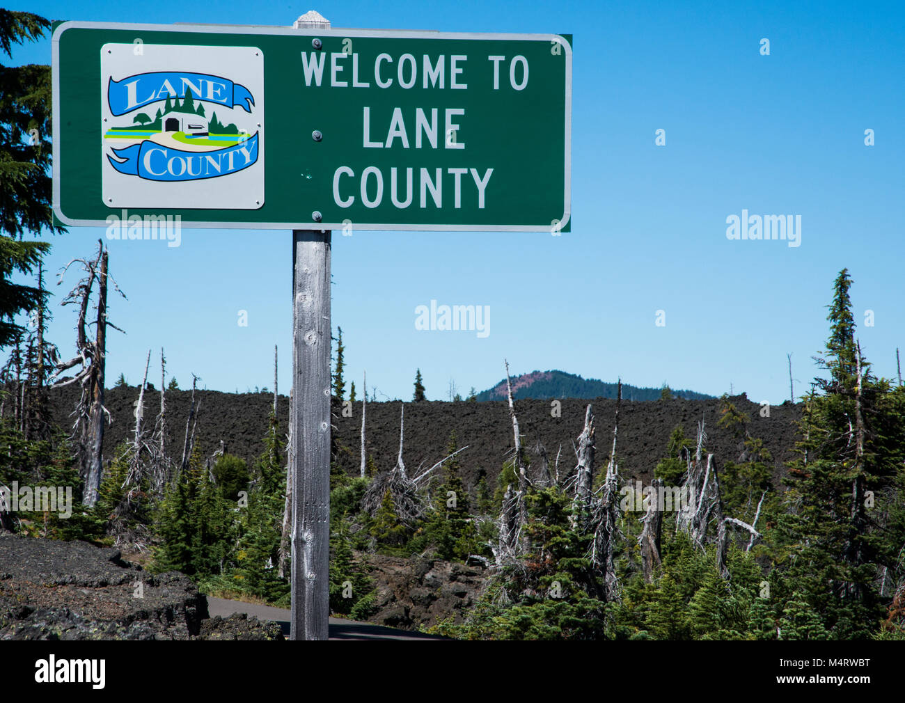 Sign entering Lane County Oregon in lava fields of the Cascade ...