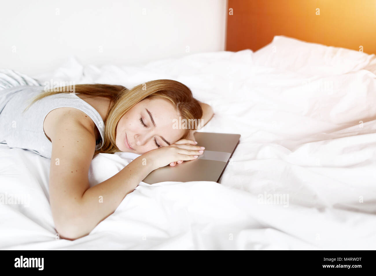 woman tired of work sleep at laptop bed with white linen at home Stock ...