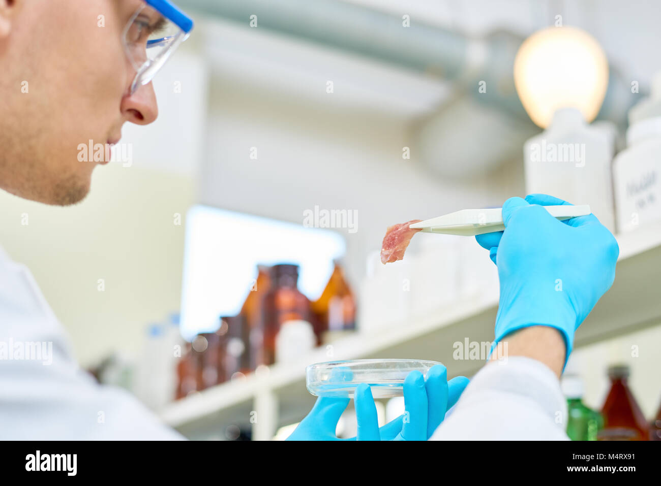 Close-up shot of confident young scientist wearing safety goggles and ...