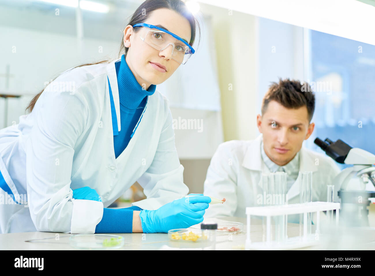 Group portrait of talented young scientists wearing white coats looking ...