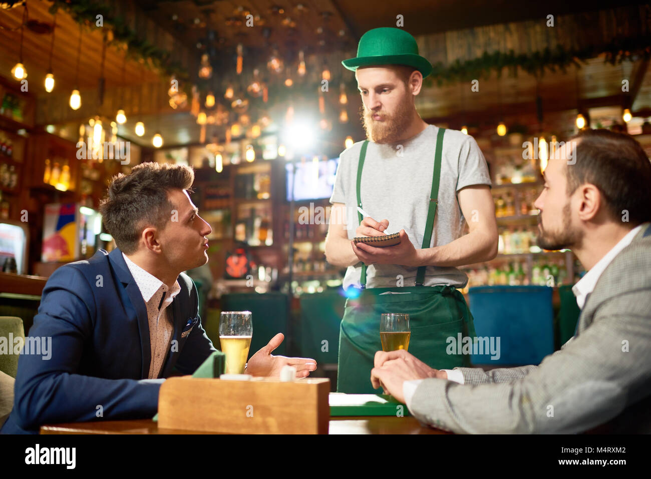 Handsome young man wearing stylish suit sitting at cafe table with his ...