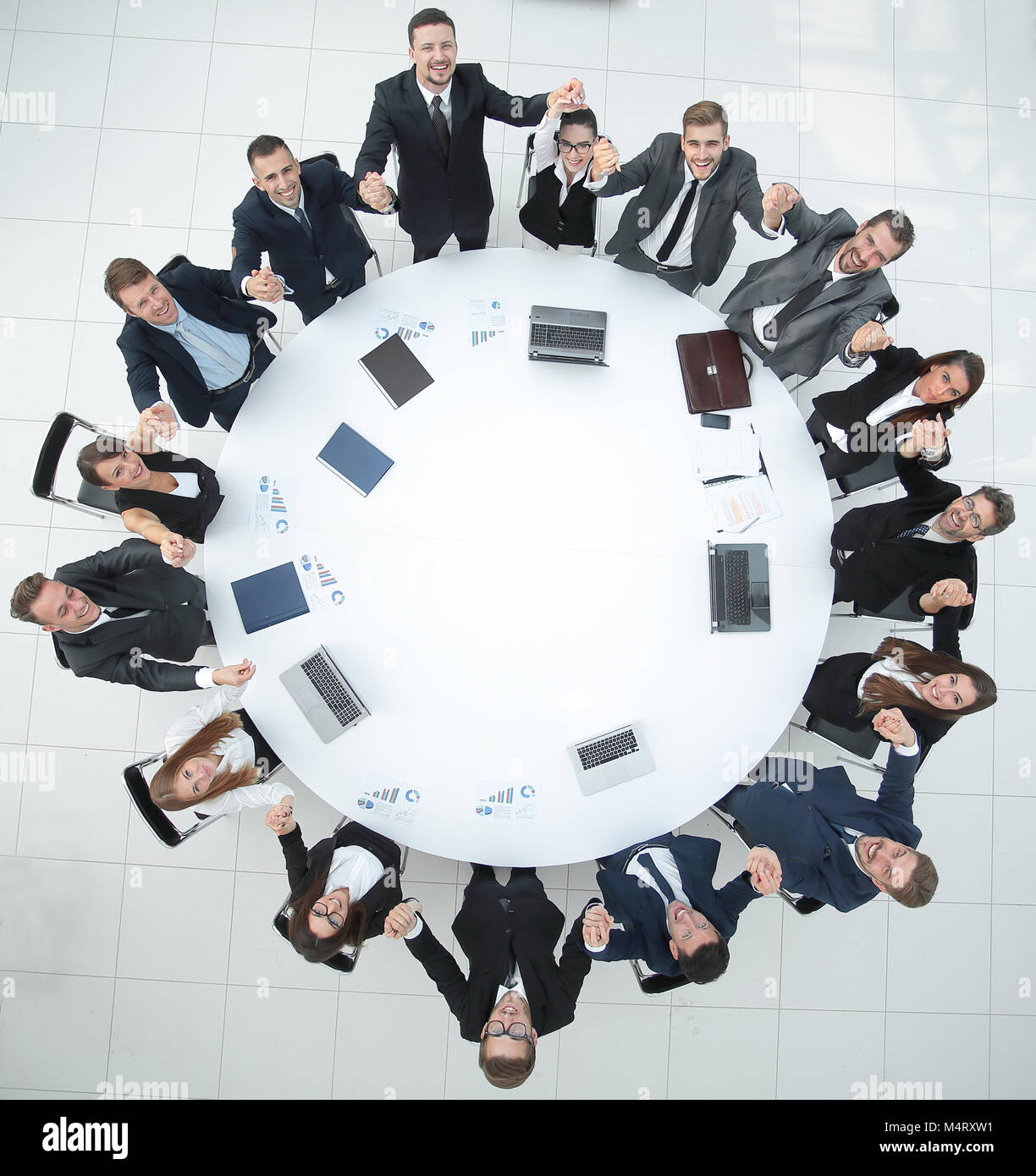 large business team sitting at the round table and raising his hands up ...
