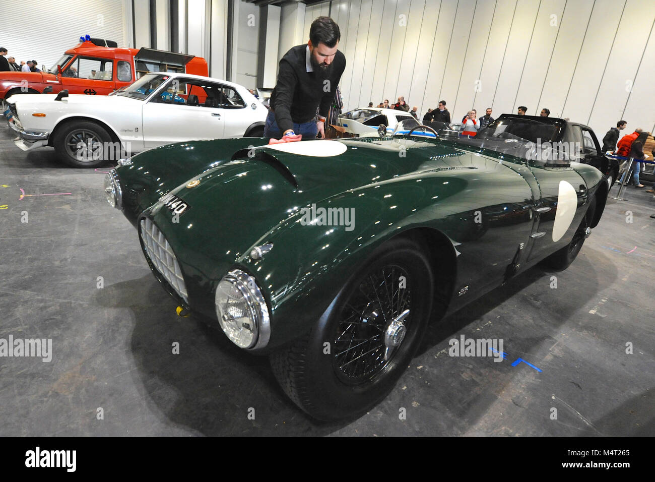 A man polishing a 1955 Jaguar XK140 Special racing car on display at ...
