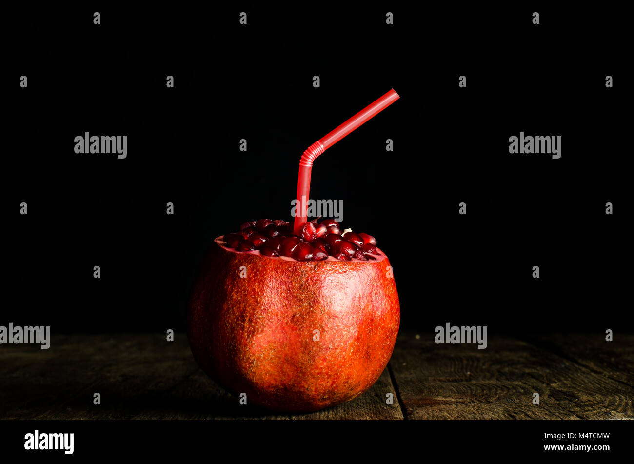 ripe garnet with drinking straw on a rustic wooden background Stock ...