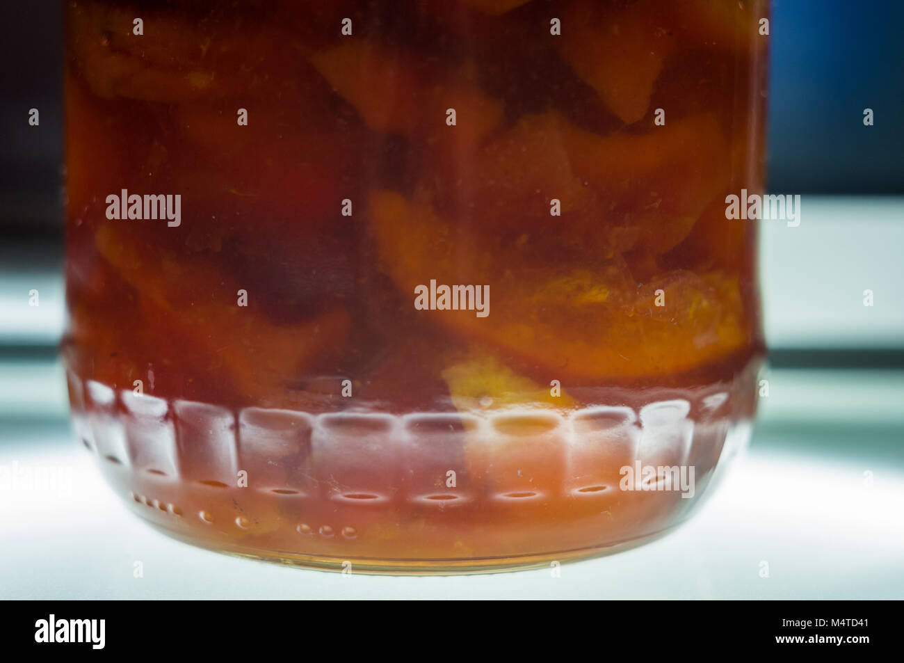 Bright translucent jam of different fruits in a glass jar, close-up ...