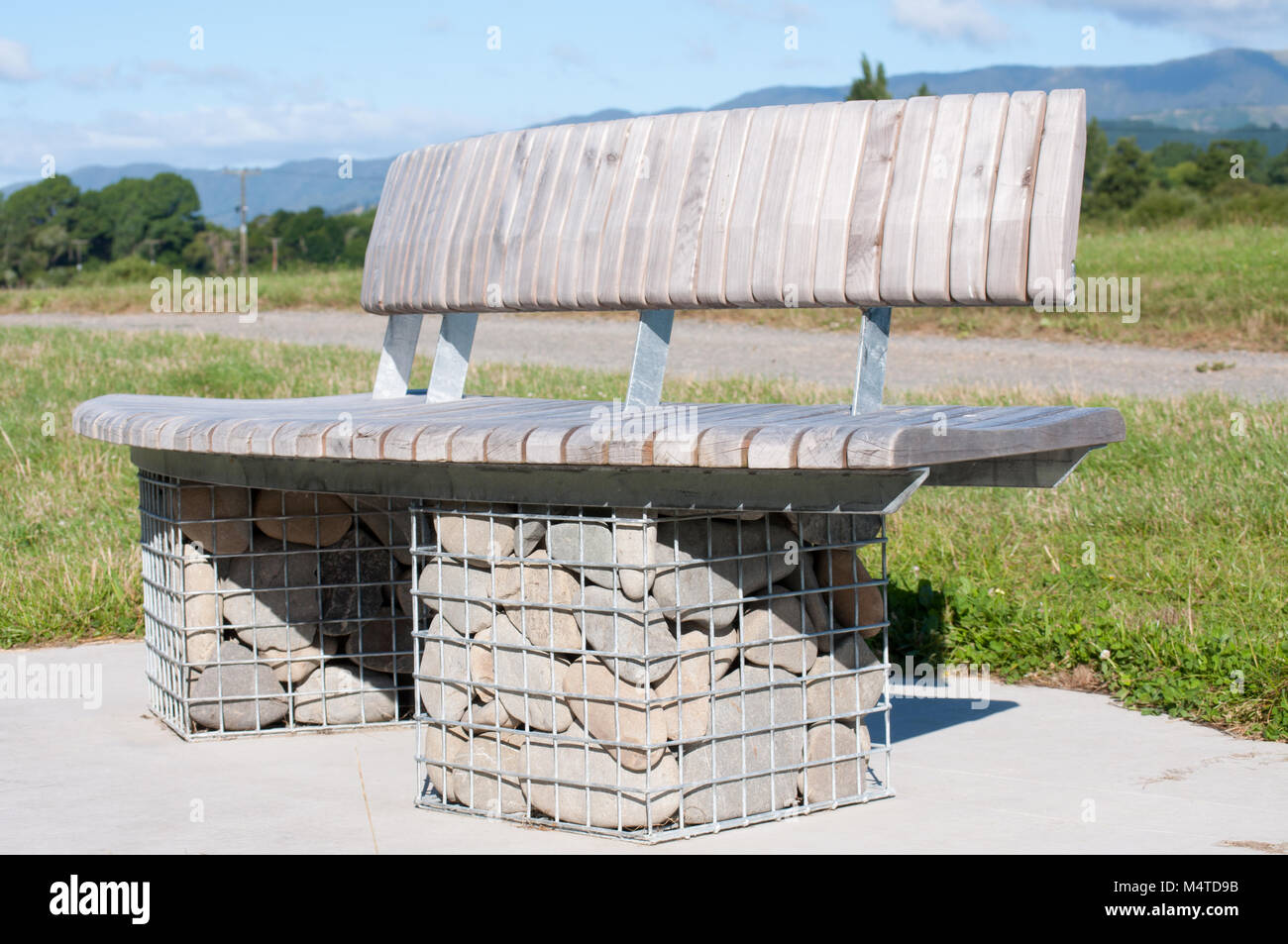 Wooden Outdoor Seat With A Rock Base Stock Photo - Alamy