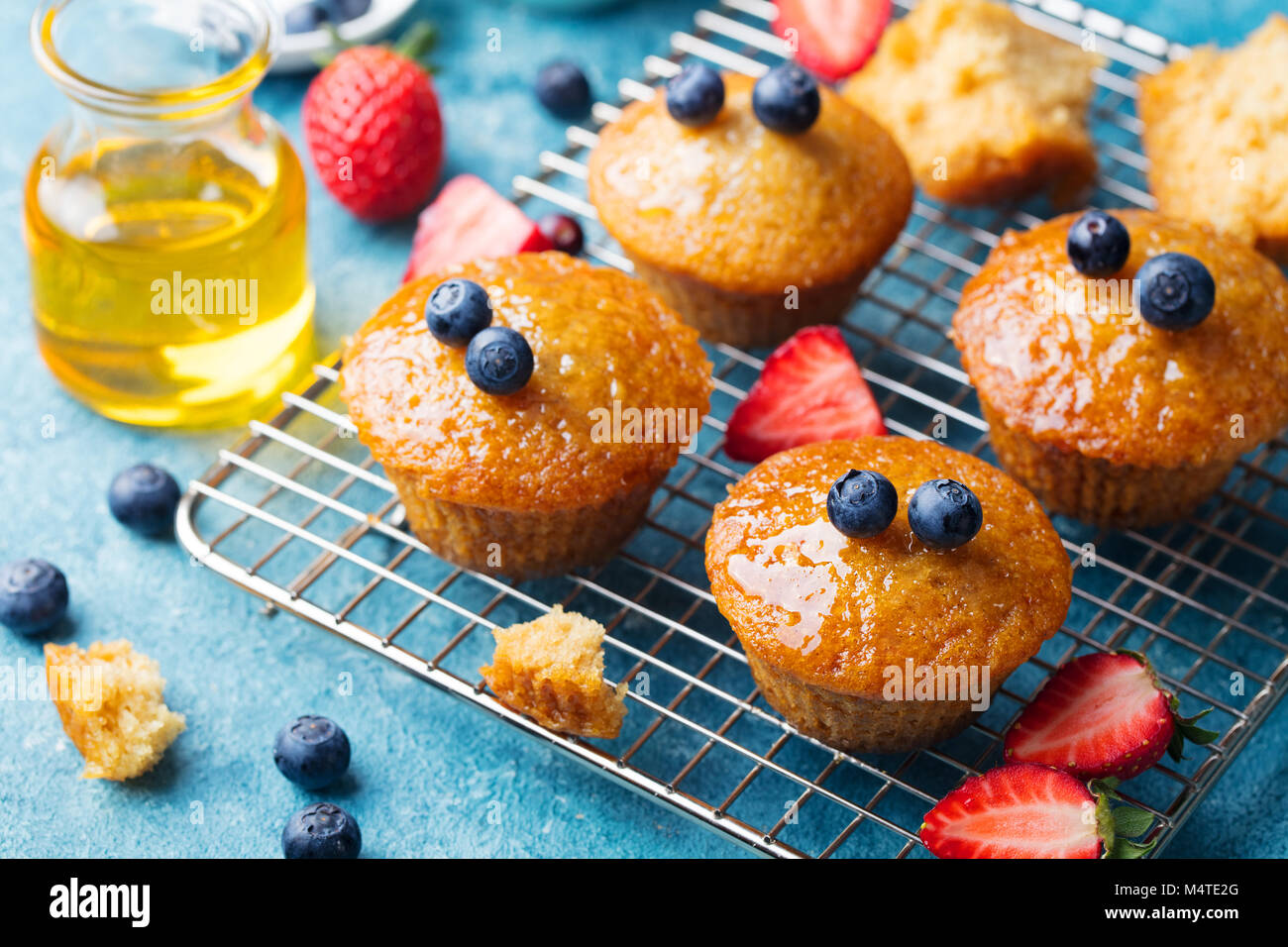 Muffins,cakes with fresh berries and honey on cooling rack Stock Photo ...