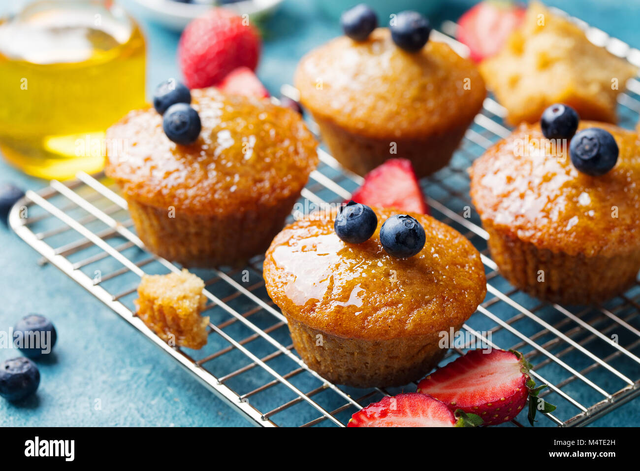 Muffins,cakes with fresh berries and honey on cooling rack Stock Photo ...