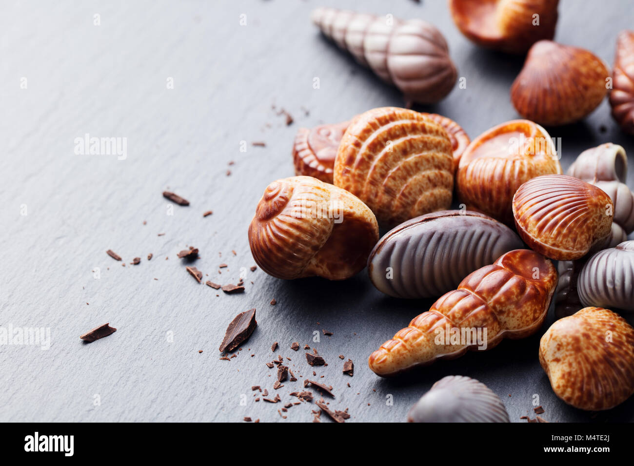Chocolate candies, traditional Belgian shell shape. Black slate ...