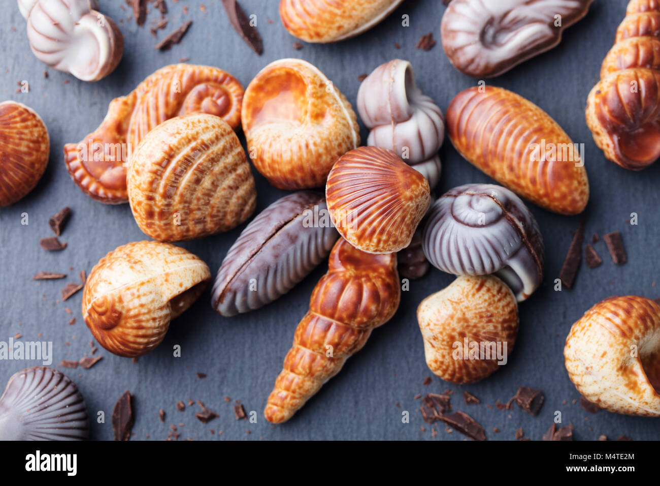 Chocolate candies, traditional Belgian shell shape. Black slate ...