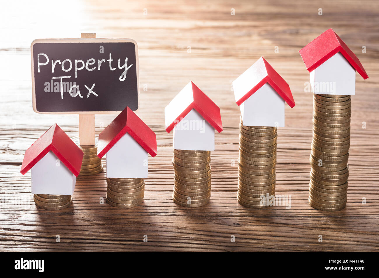 House Models On Increasing Coin Stacked With Property Tax On Chalk ...