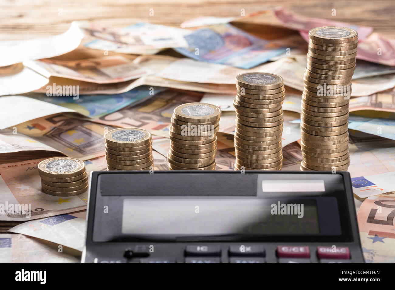 Close-up Of A Calculator With Coin Stacked And Currency Notes On Table ...