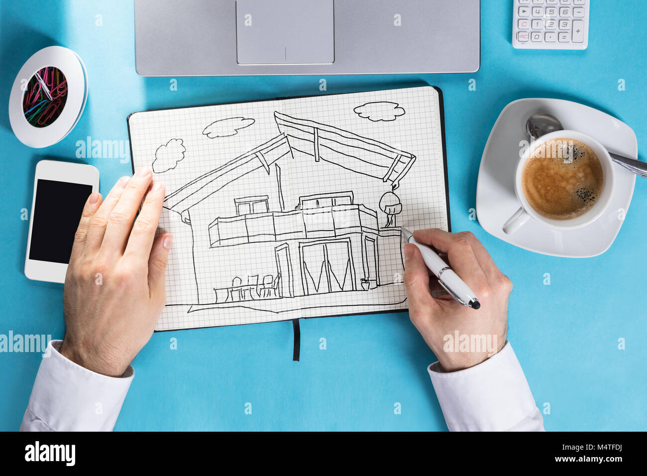 Overhead View Of A Businessman Drawing House On Checkered Notebook At ...