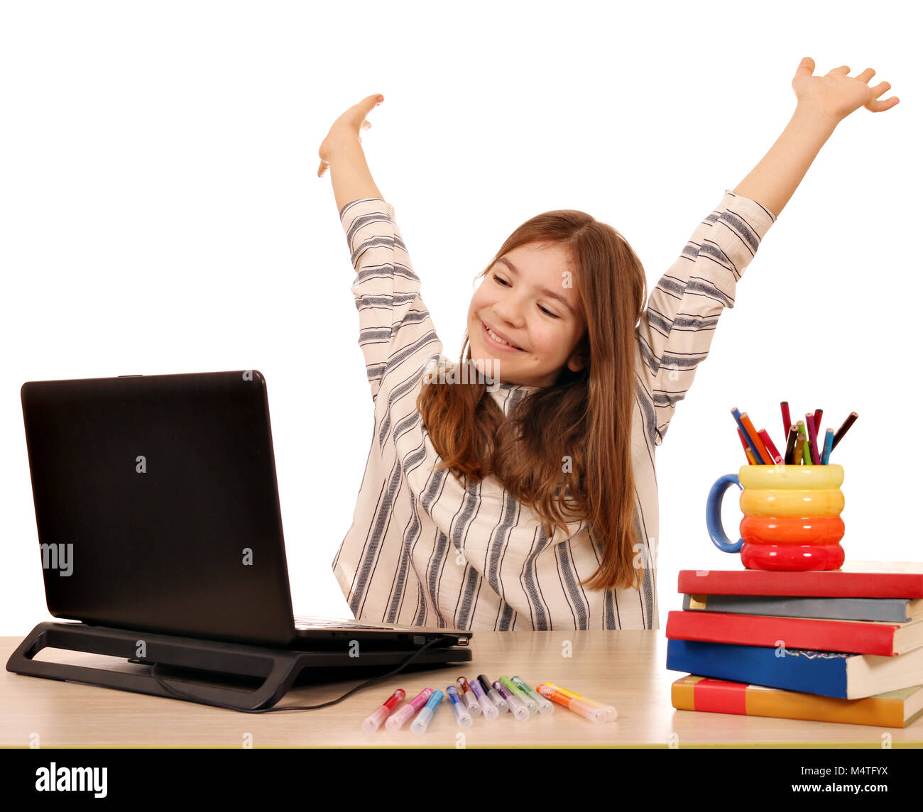 Happy little girl with hands up and laptop at home Stock Photo - Alamy
