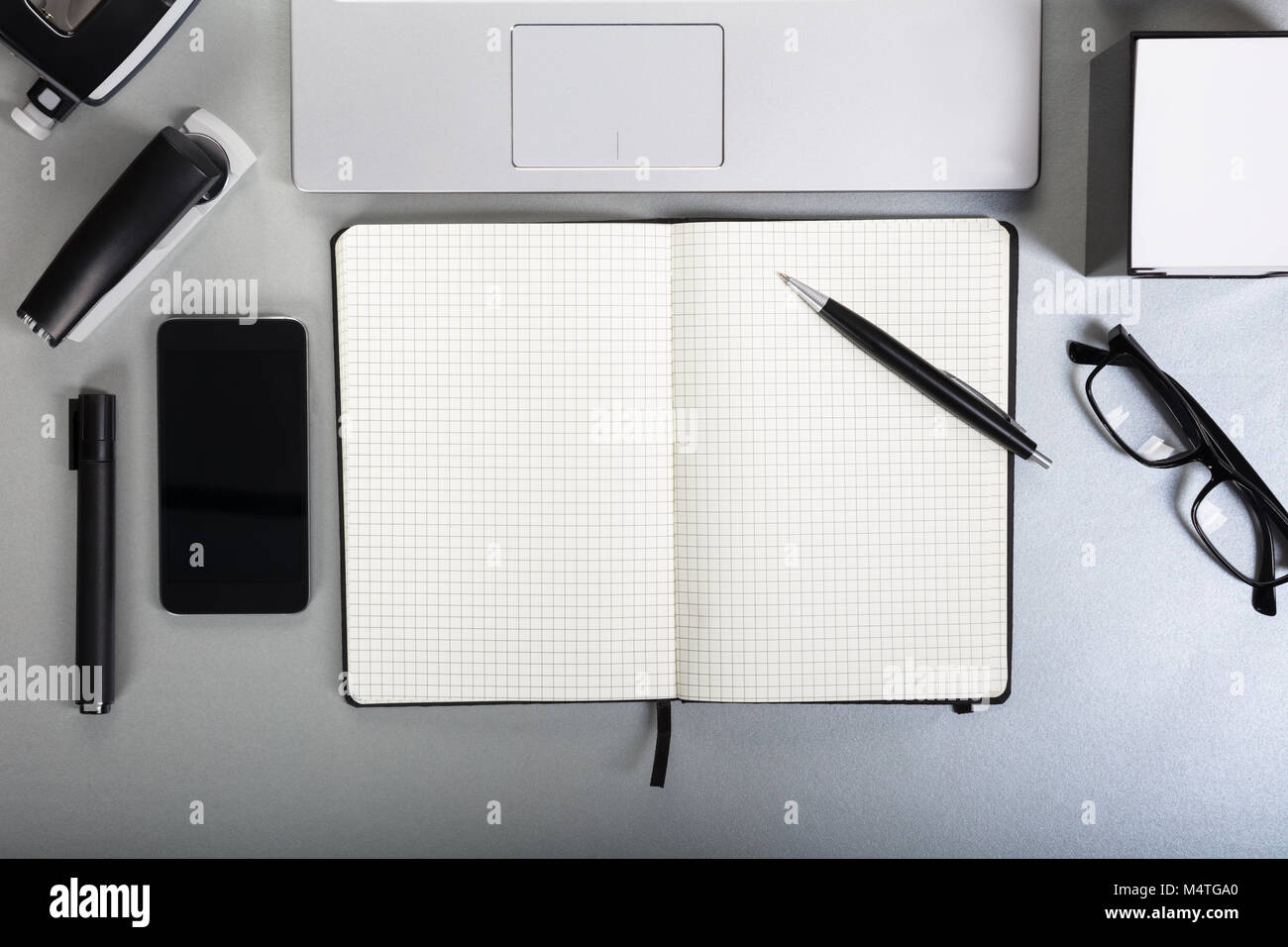 Overhead View Of Office Desk With Checkered Notebook And Office ...