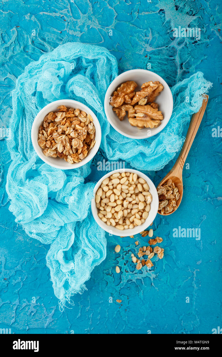 Set of different types of nuts - peanuts in shells, pine nuts on blue ...