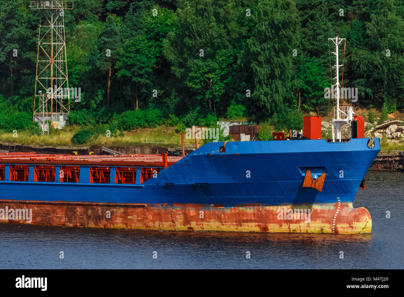 Blue cargo ship with long reach excavator moving to the port Stock ...