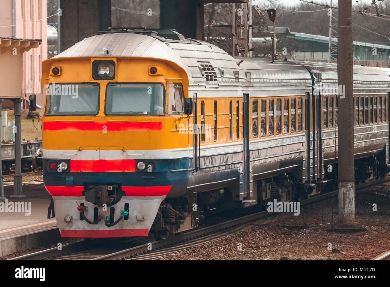 Old yellow passenger diesel train moving at the terminal Stock Photo ...
