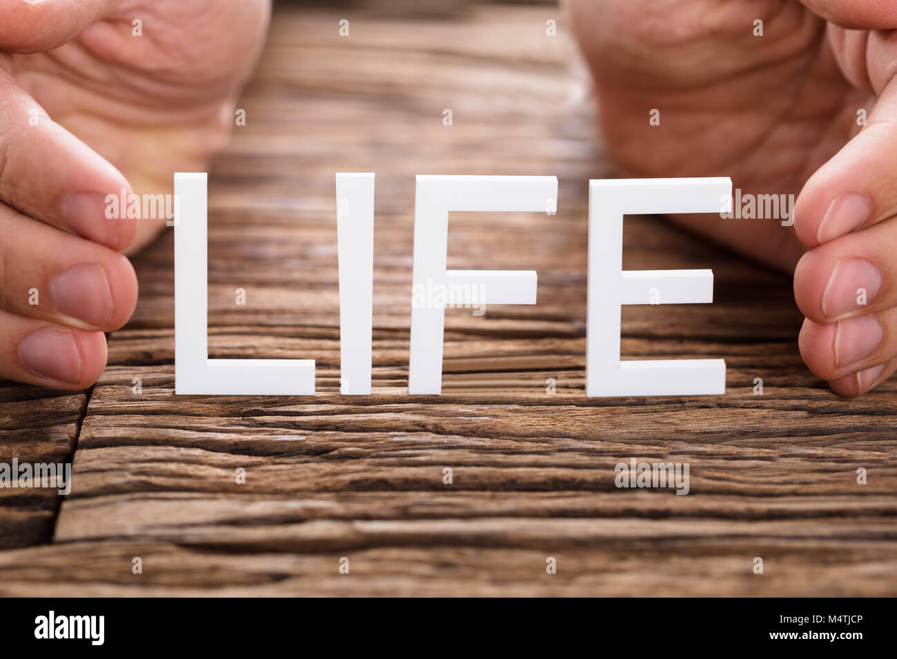 Close-up Of A Person Protecting Life Text Om Wooden Table Stock Photo ...
