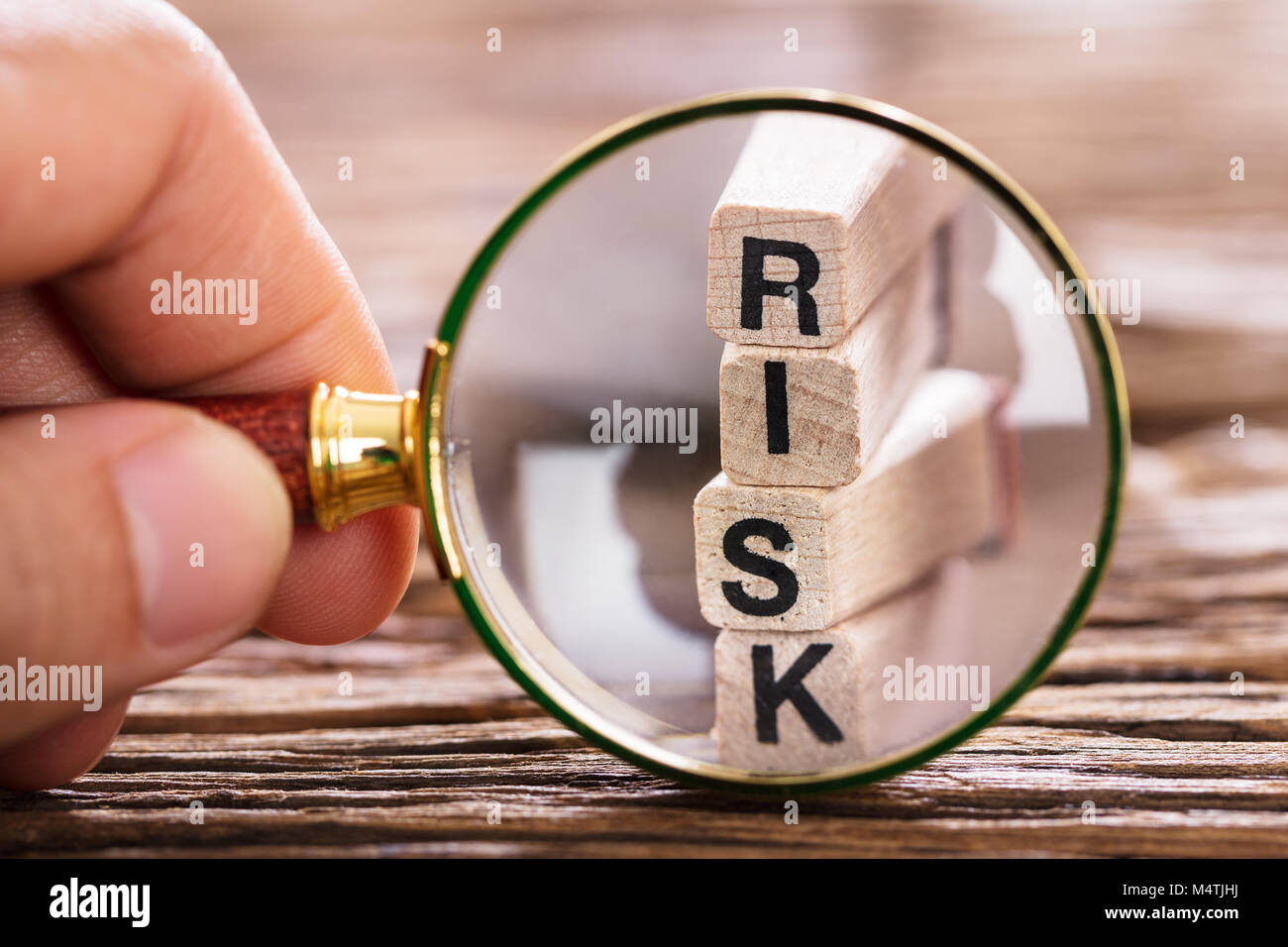 Close-up Of A Person Inspecting Risk Block With Magnifying Glass On ...