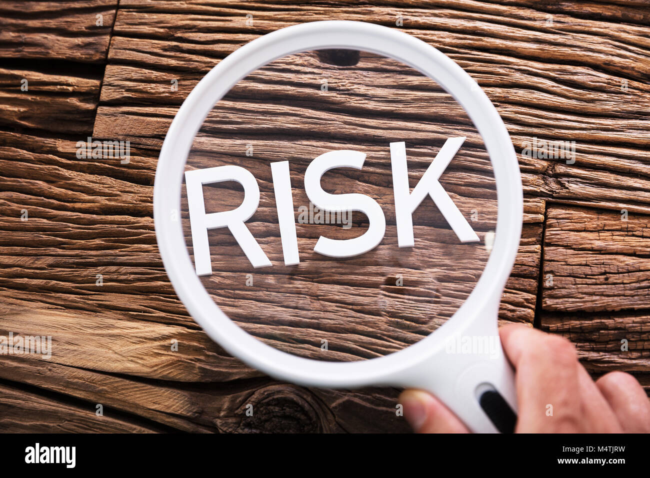 Elevated View Of A Person Looking At Risk Text Through Magnifying Glass ...