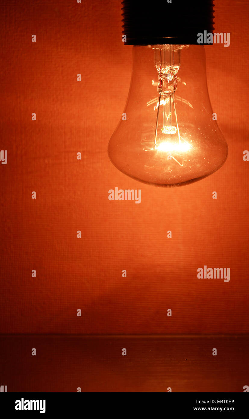 Closeup of glowing light bulb on nice red wall background Stock Photo ...