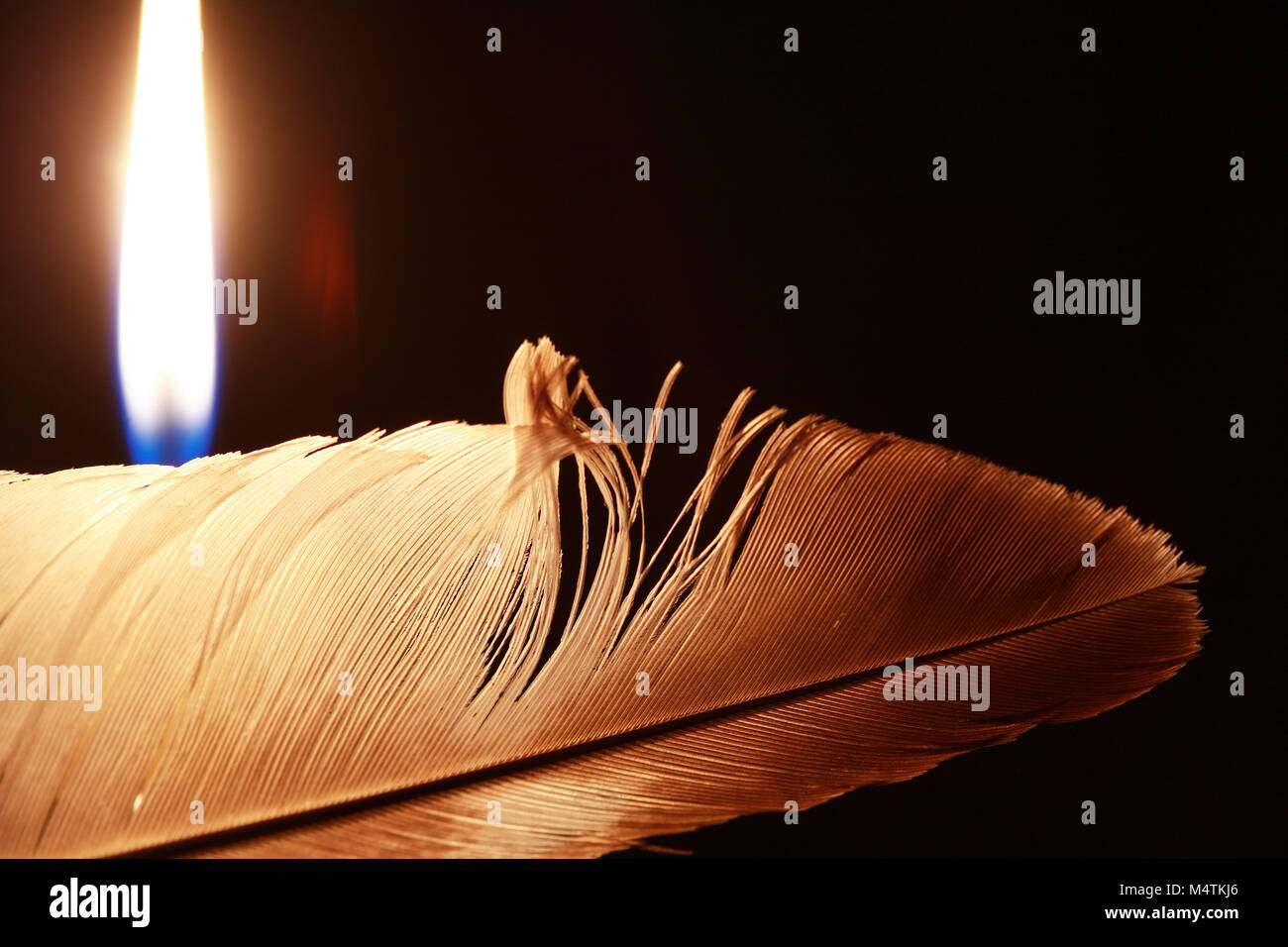 Vintage still life with lighting candle near feather closeup Stock ...