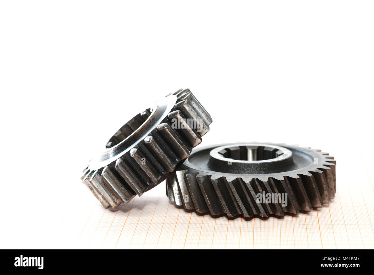 Engineering concept. Two gears closeup on graph paper with free space ...