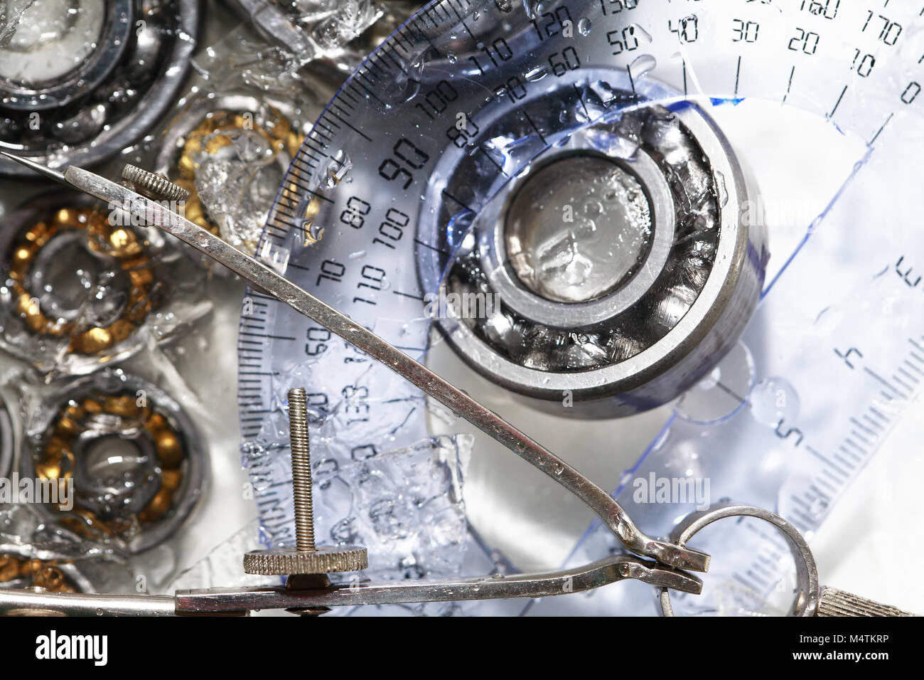 Machinery concept. Closeup set of ball bearings under frozen water ...
