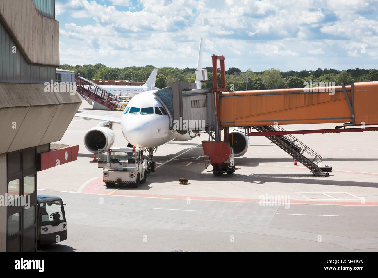 Passenger boarding bridge attached to airplane on runway Stock Photo ...