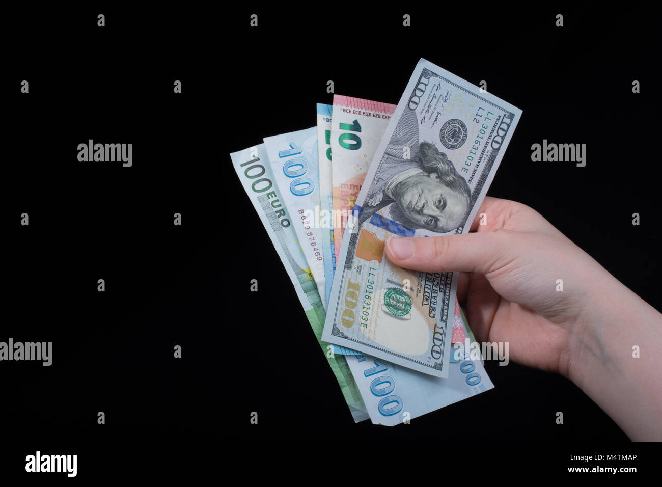 Hand holding American dollar banknotes isolated on black background ...