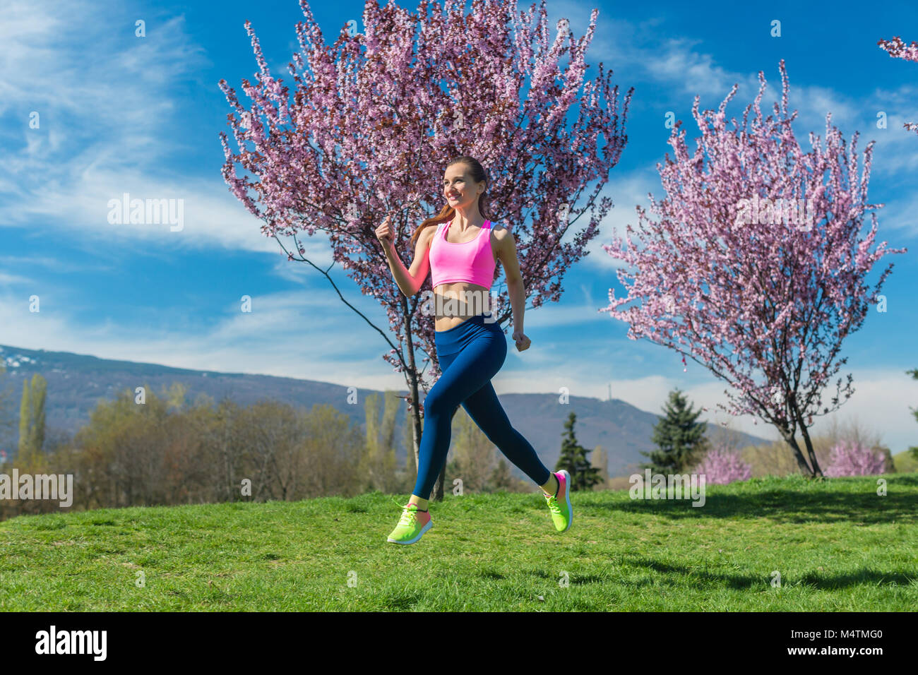 Woman doing sport running on hill between blossoming cherry trees Stock ...
