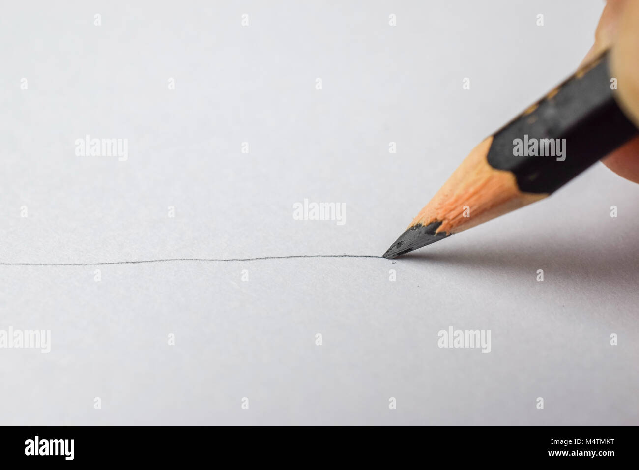 Drawing a line on white paper with a pencil - close-up Stock Photo - Alamy