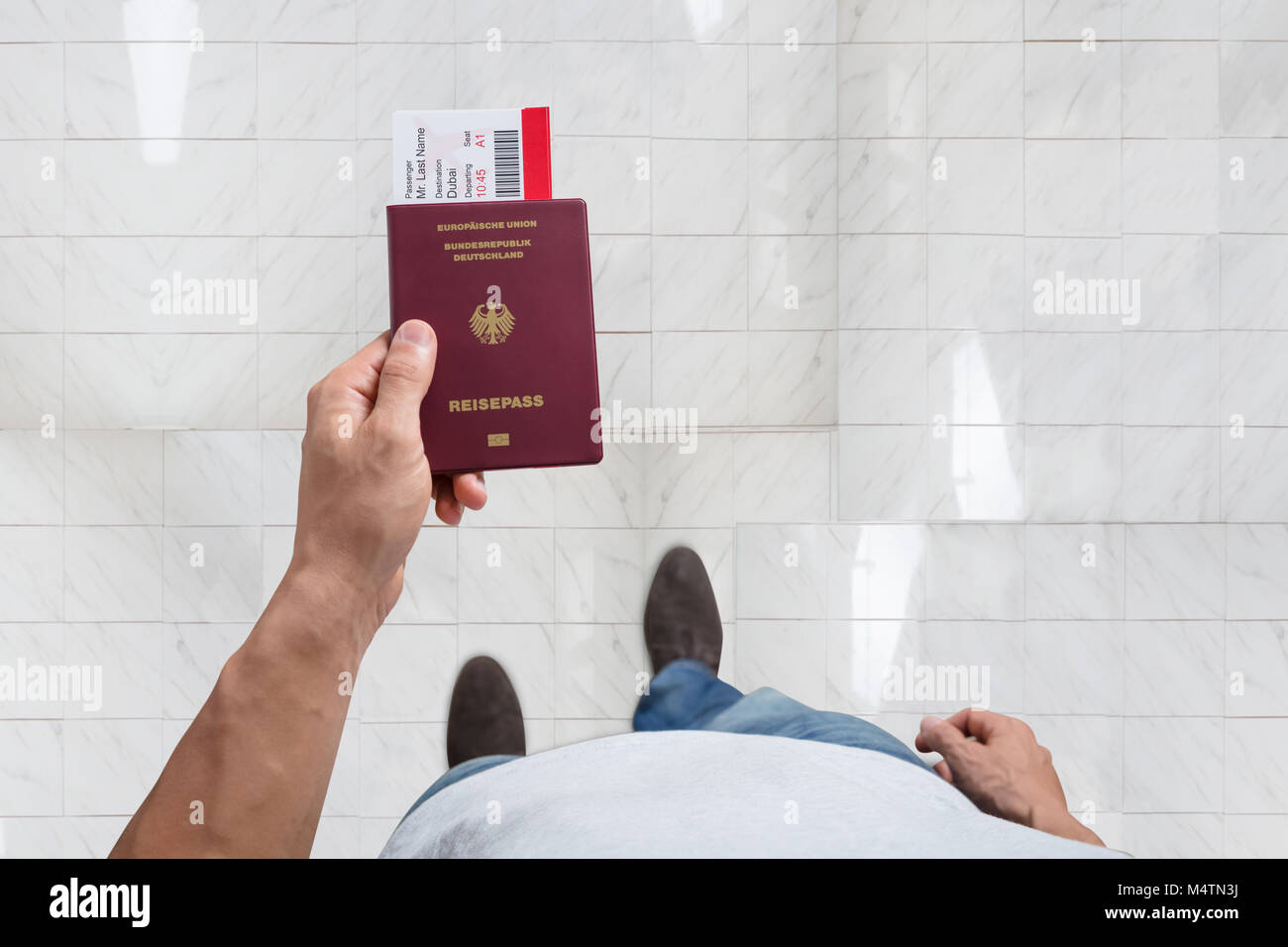 Elevated View Of Males Hand Holding Passport And Boarding Pass