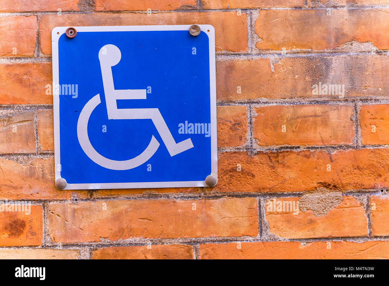 Blue handicap sign on brick wall Stock Photo - Alamy