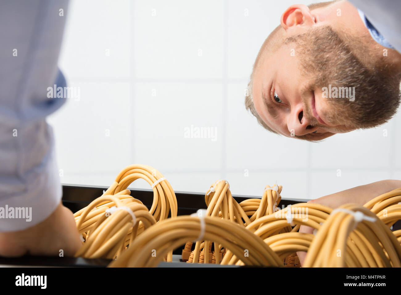 Male Technician Checking Cables In A Rack At Server Room Stock Photo ...