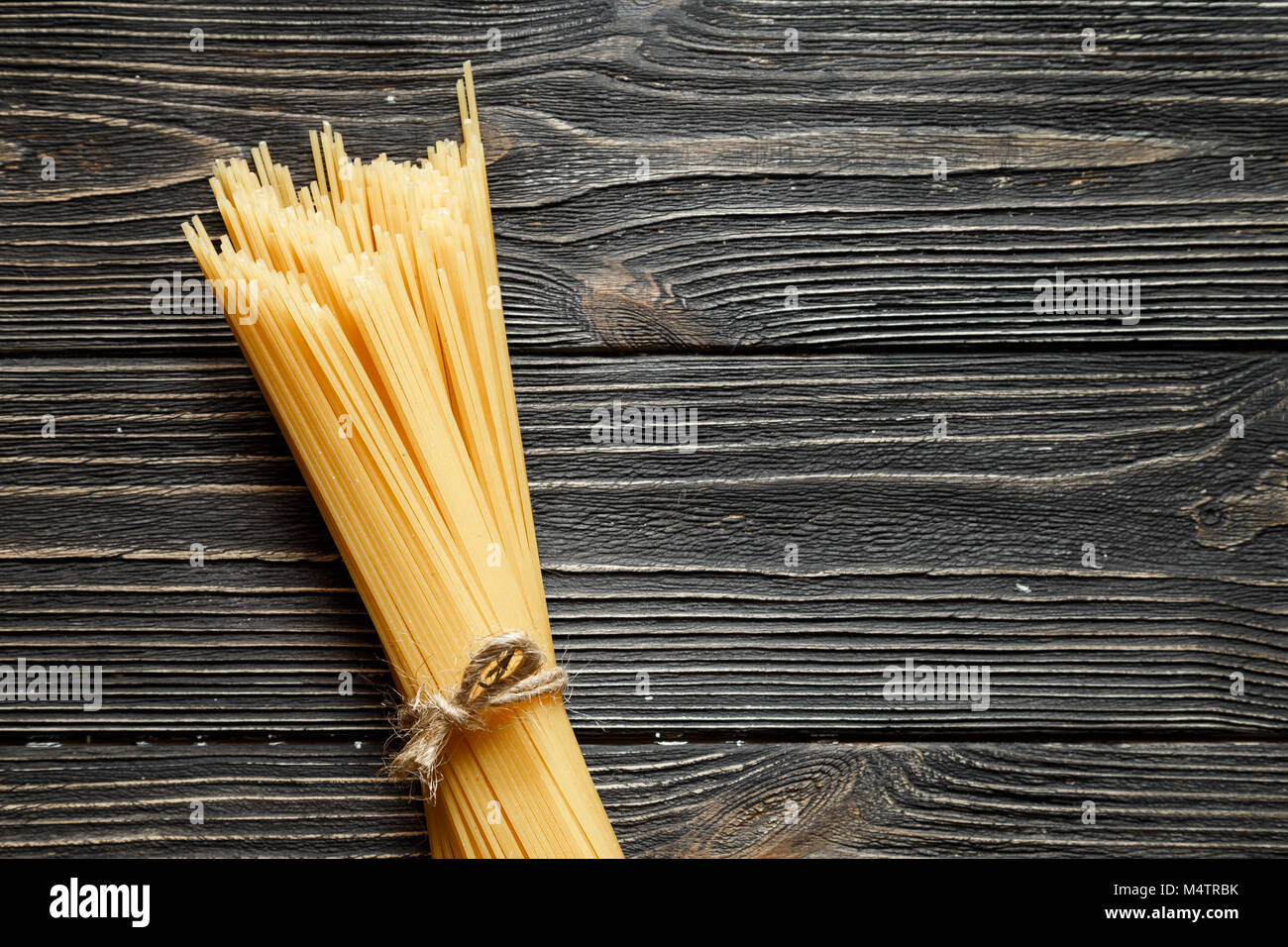 Banch of spaghetti on dark wooden table. Top view Stock Photo - Alamy