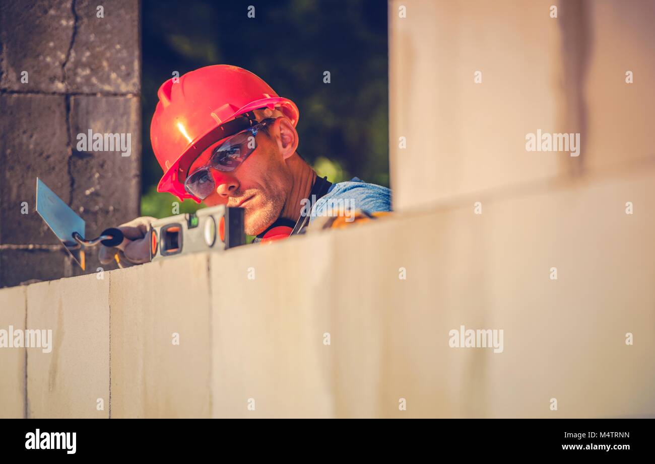 Caucasian Mason Worker in Red Hard Hat Taking Look Through the Building ...
