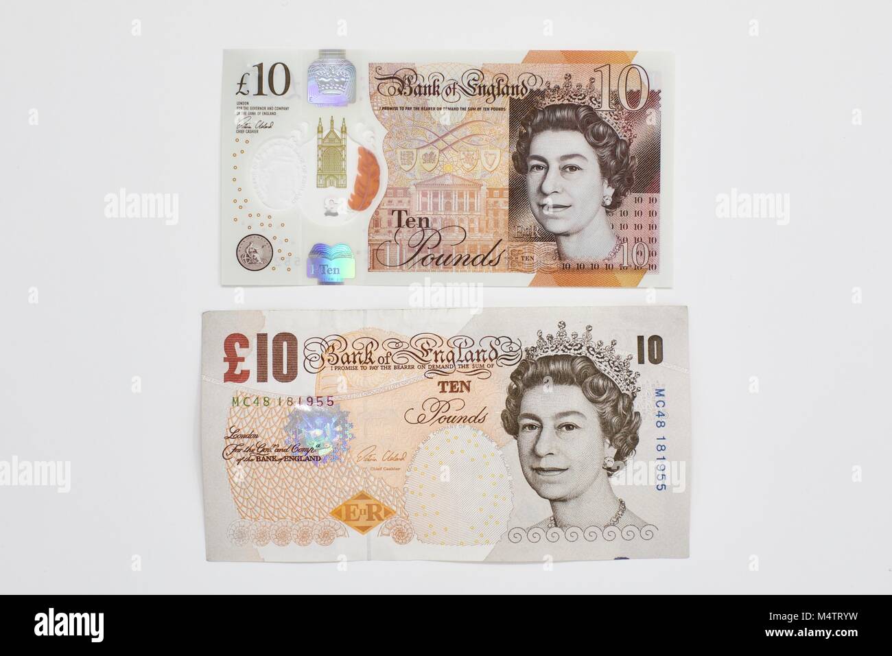 The new polymer £10 banknote and the old £10 pound banknote on a white ...