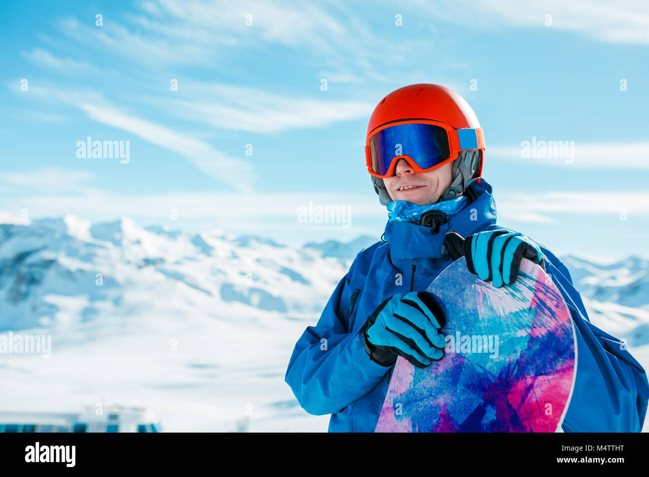 Photo of sportive man in helmet looking into camera with snowboard on ...